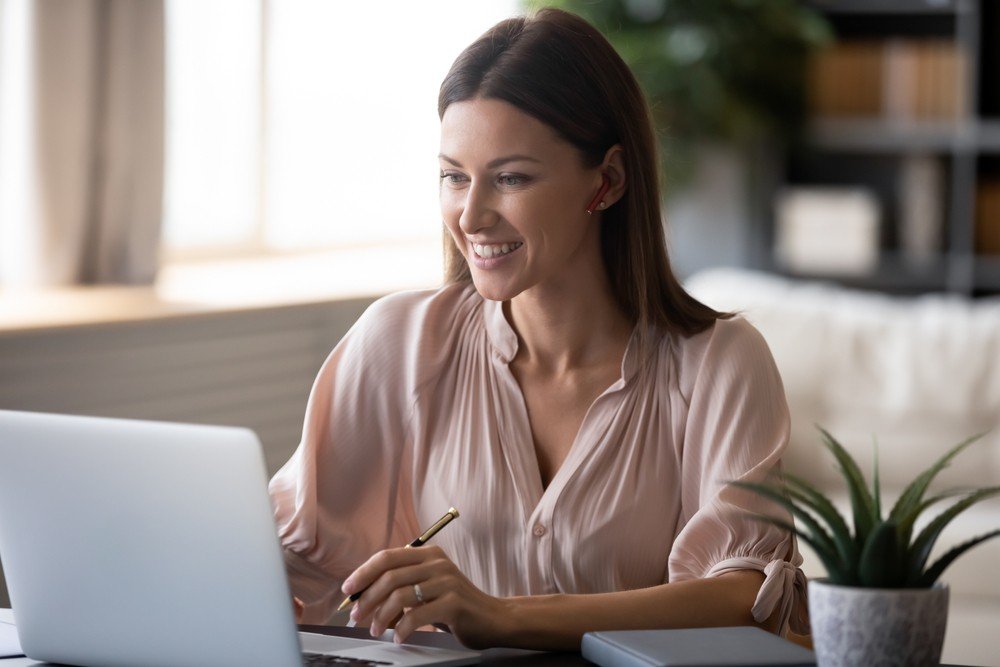 Close,Up,Smiling,Woman,Wearing,Wireless,Earphones,Using,Laptop,,Sitting ...